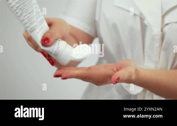 Spa therapist dispensing nutritious fortified cream on to hand for ...