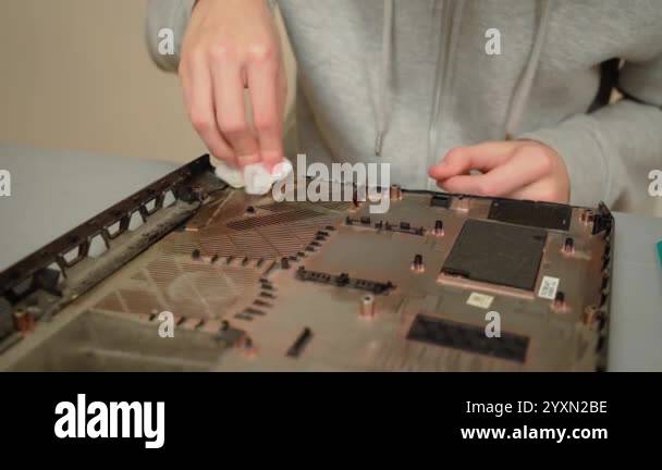 Boy cleaning laptop cover during repair process with cloth. Wiping off ...