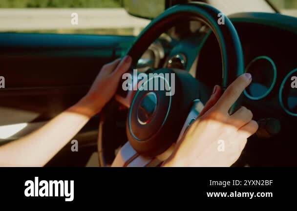 Hands holding steering wheel driving automobile under bright daylight ...