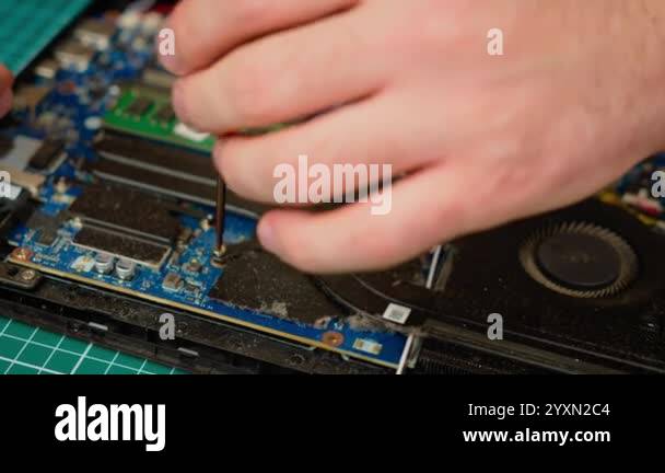 Hands fixing laptop components, holding screwdriver and carefully ...