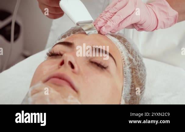 Professional using ultrasonic facial device during skin care treatment ...