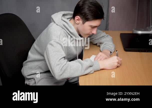 Teenager writes with pen on sheet of paper. Handwriting with pencil ...