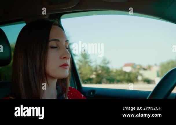 Woman driving car with focused expression, hands confidently holding ...