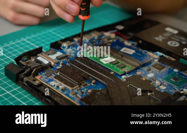 Son unscrewing bolts while assisting father in laptop cooling system ...