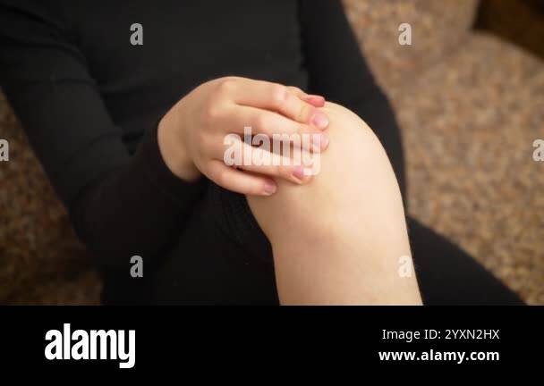 Teen girl massaging her knee after strain. Adolescent girl soothing ...