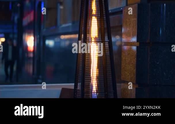 Street heater glowing warmly on night street near cafe, casting light ...