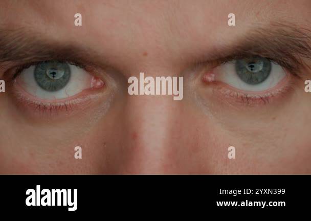 Intense gaze with gray eyes. Male face with focused expression. Close ...