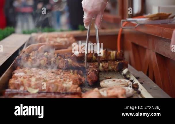 Street vendor is preparing skewers and sausages on grill at Christmas ...