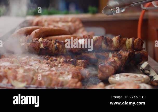 Street vendor is preparing skewers and sausages on grill at Christmas ...