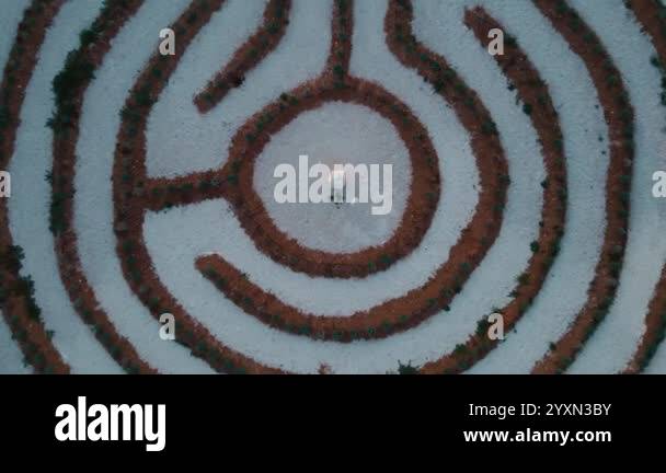 Top view of circular labyrinth surrounded by lush greenery. Hedge maze ...