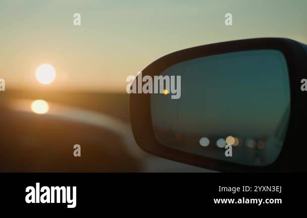 Car driving on highway at sunset with working blind spot alert in rear ...