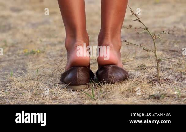 The girl puts on her shoes.Women's feet without shoes.Walking barefoot ...