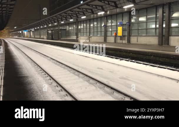 onset of winter at railways station at night. freshly untouched snow ...