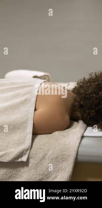 Woman lying on a massage table, enjoying a moment of relaxation while ...
