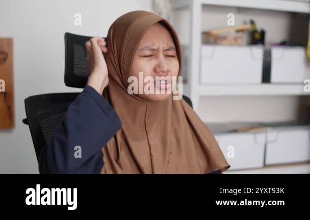 Young Asian muslim woman looks confused when sitting in front of a ...