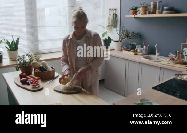 Medium shot of adult Caucasian woman grating parmesan cheese and ...