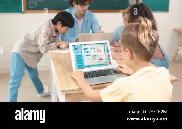 Cute caucasian boy coding program and looking at camera in STEM ...