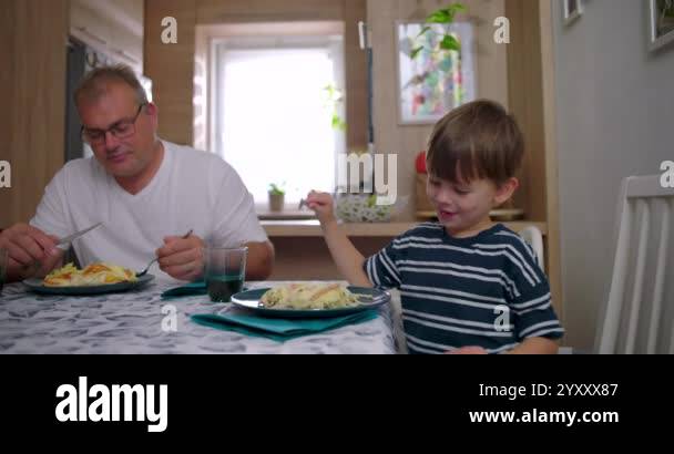 Family eating together at the table, candid moment showing parents and ...