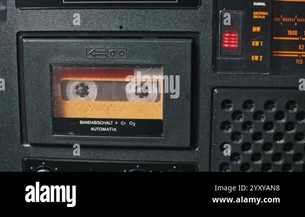 A detailed shot of a vintage cassette tape player with a tape inserted ...