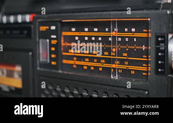 Close-up of a vintage radios dial, showcasing an orange indicator ...