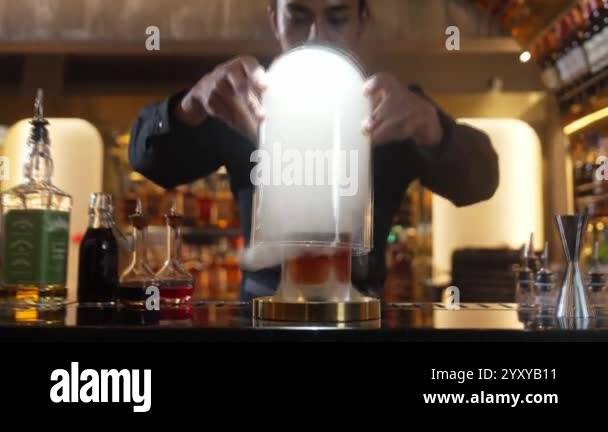 Asian bartender serving mist smoky classical mixing whiskey cocktail fantastic presentation ...