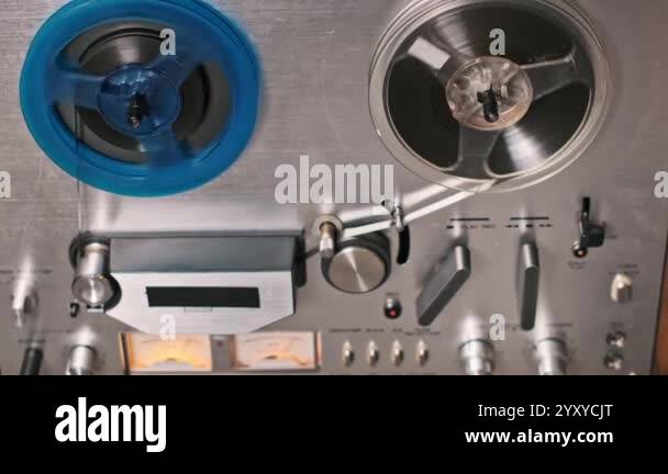 Close-up of a vintage reel-to-reel tape recorder in operation. The ...