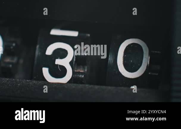 A close-up shot of a vintage number counter looping from 0 to 230 ...