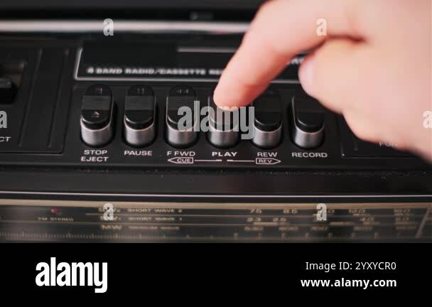 Close-up of a finger pressing the play button on a vintage cassette ...