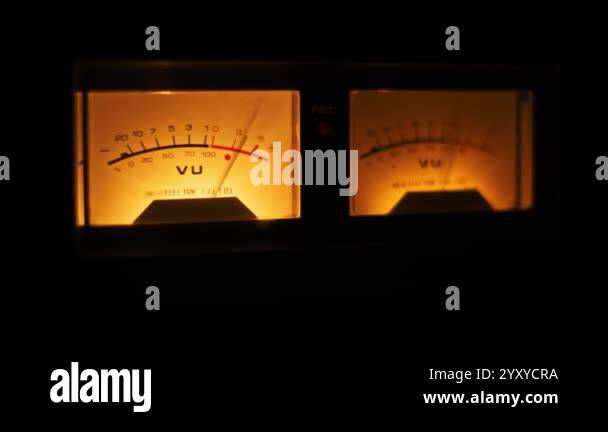 Close-up of an analog audio meter with illuminated needles, showcasing ...