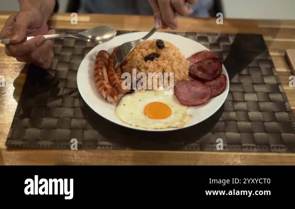 Close up shot of senior man eating fried rice for lunch on wooden ...