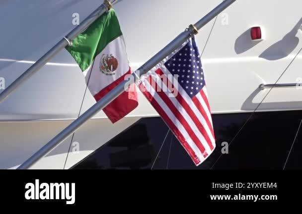 The Mexican and American flags fly side-by-side, signifying a ...