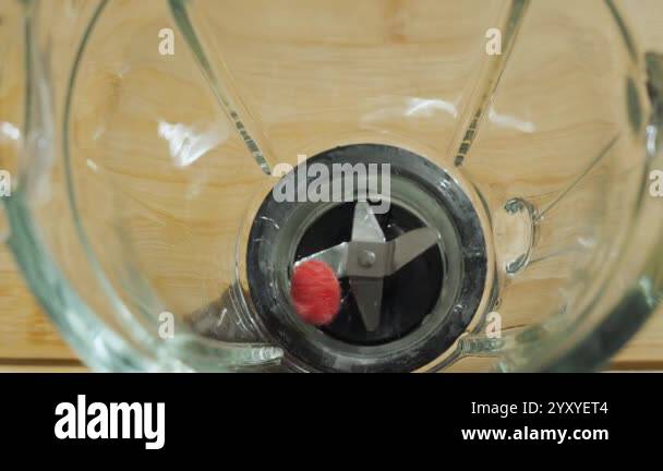 Adding raspberries, blueberries and bananas to a blender to make a ...