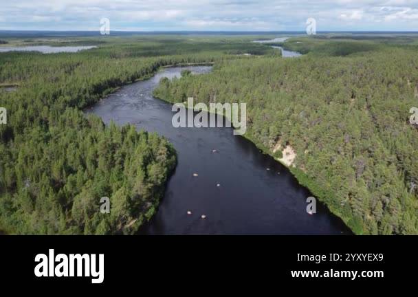 Flying up over a flowing river in the forest in northern Finland Stock ...