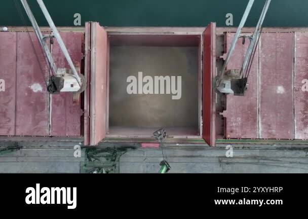 Loading dry cargo ship of wheat by cranes in port. Aerial view loading into holds of sea cargo ...