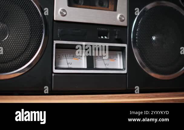Close up of a retro boombox with a cassette playing, VU meters reacting ...