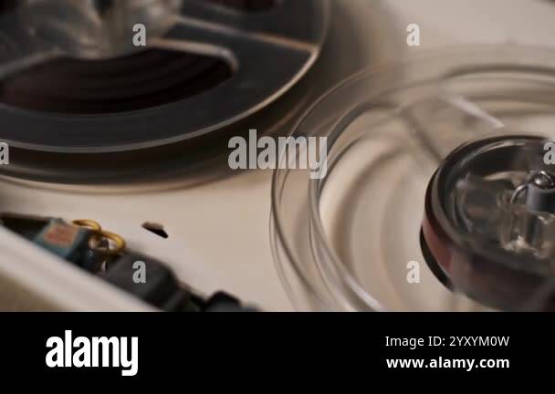 Close-up shot of vintage reel-to-reel tape recorder spinning reels ...