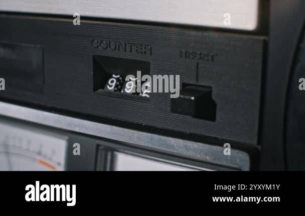 Close up shot of a vintage reel-to-reel tape recorder counter spinning ...