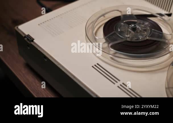 Close-up view of a retro reel-to-reel tape recorder with spinning reels ...