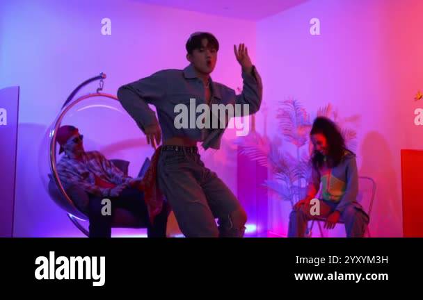 Skilled asian dancer moving to modern music while multicultural friend ...