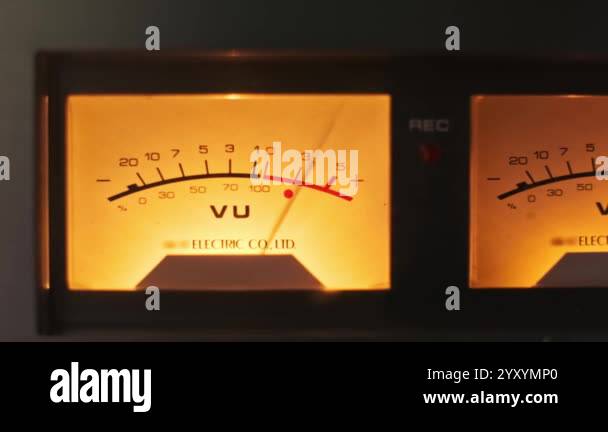 A close-up of an illuminated vintage VU meter on a classic audio device ...