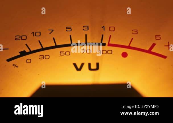 A macro view of a glowing vintage VU meter bathed in warm golden tones ...