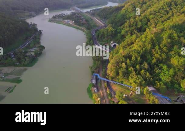 Aerial drone view of the Serayu River, the highway and railroad tracks ...