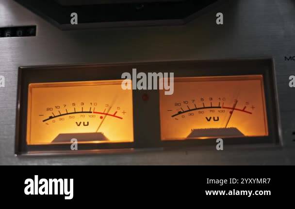 Close-up of glowing amber VU meters on a retro analog audio device, perfect for themes involving ...