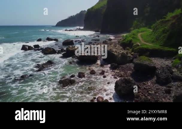 Aerial drone view of coastline with hills and trees, as well as view of ...