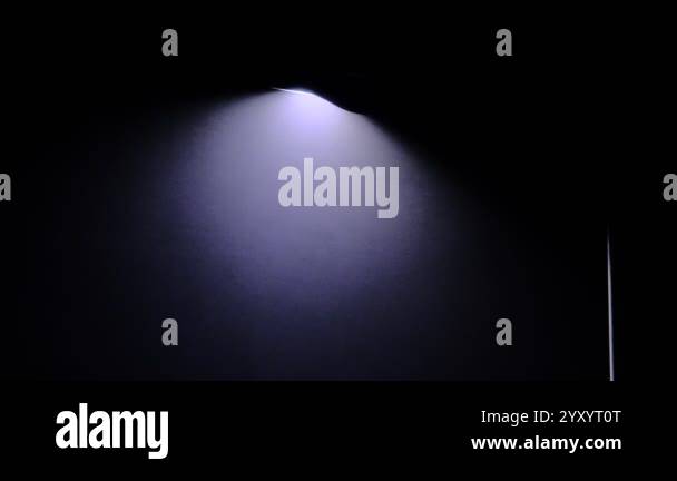 Mist floating past a street lamp at night, close view. illuminated by ...