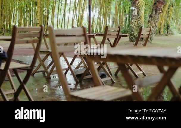 Peaceful scene of an empty outdoor cafe with wooden chairs and tables ...