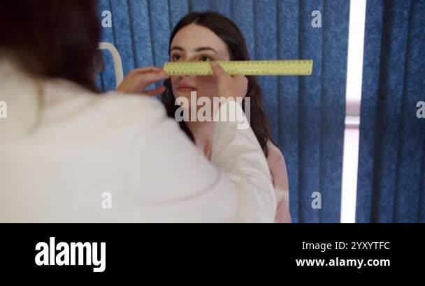 A healthcare professional carefully measures facial dimensions using a ...