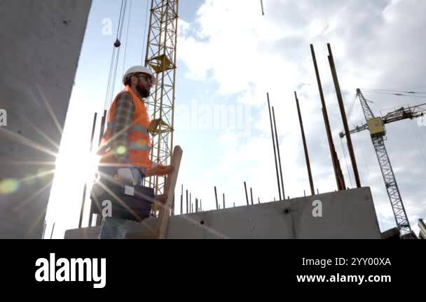 Maintenance worker man with safety helmet and orange vest climbing wood ...
