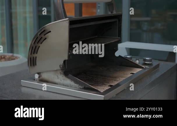 A modern stainless steel grill is ready and waiting for outdoor cooking ...