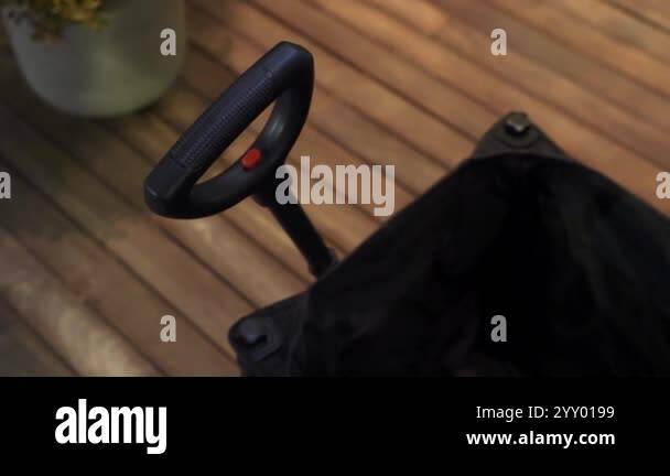 Here is a closeup view of a stylish and sleek black stroller handle ...